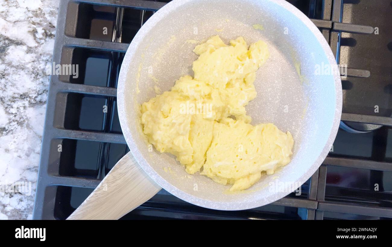 Whisking Golden Eggs in Pan Over Gas Stove for Breakfast Stock Photo ...