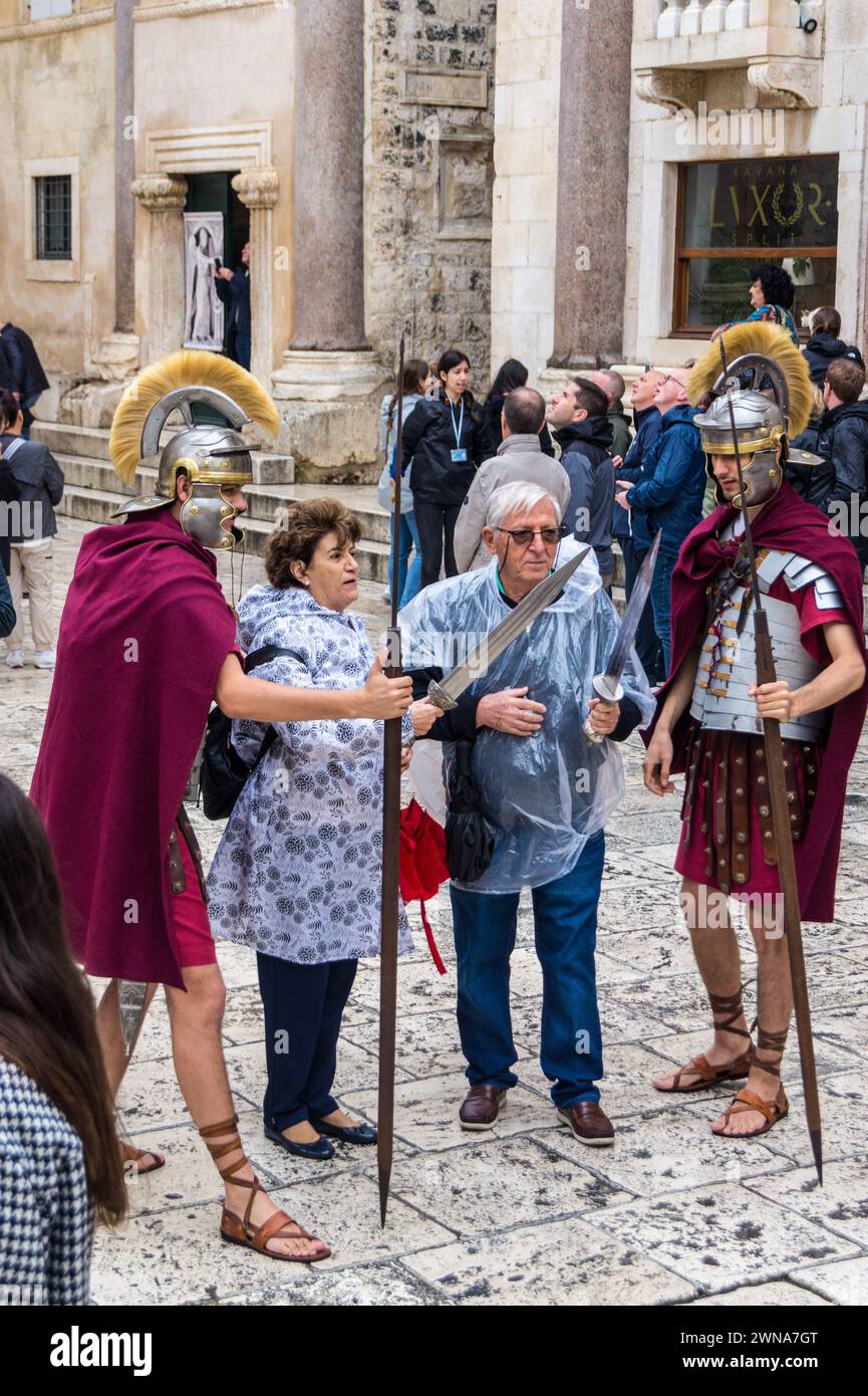 Actors in Roman soldiers' uniform posing with tourists for photographs ...