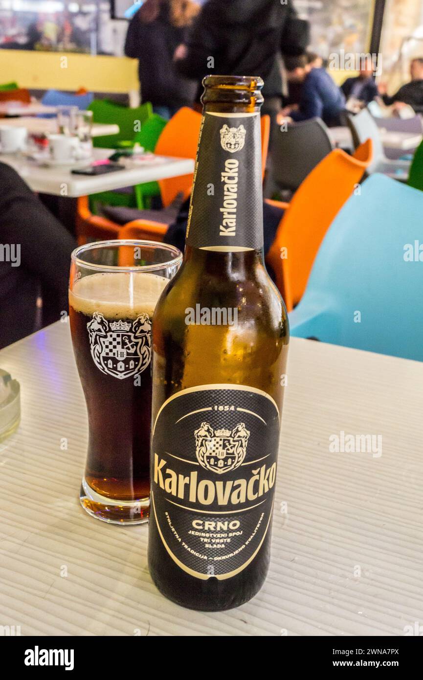 A bottle and glass of Karlovacko dark lager beer on a bar, Split ...