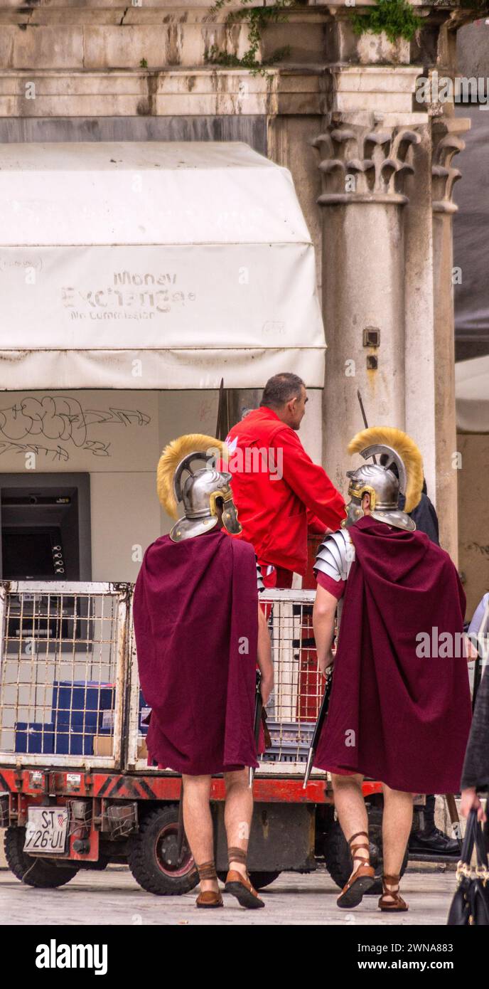 Actors in Roman soldiers' uniform posing with tourists for photographs ...