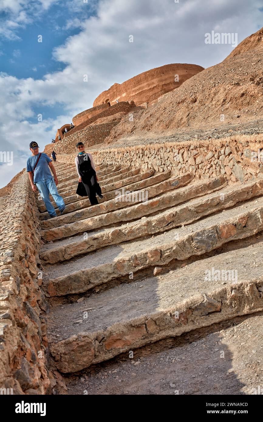 Tourists walk down a stone stair after visiting the Tower of Silence ...