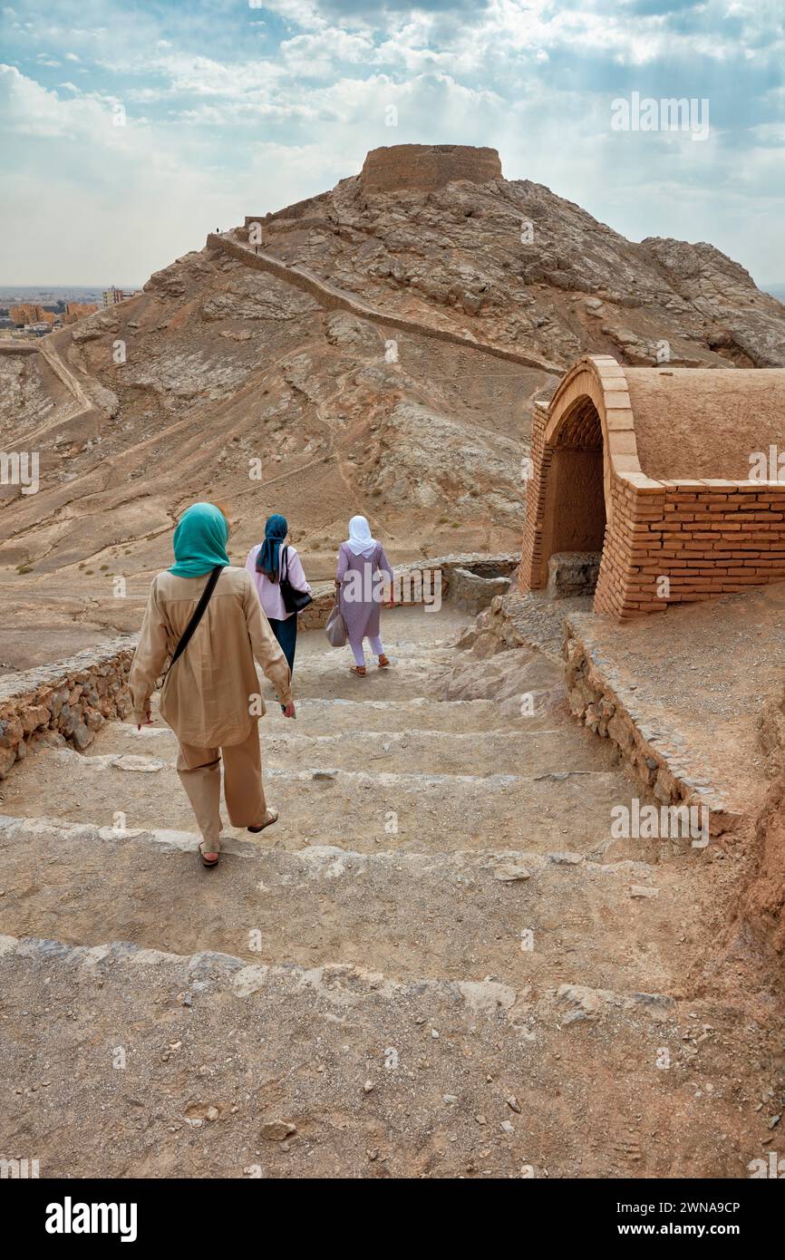 Tourists walk down a stone stair after visiting the Tower of Silence ...