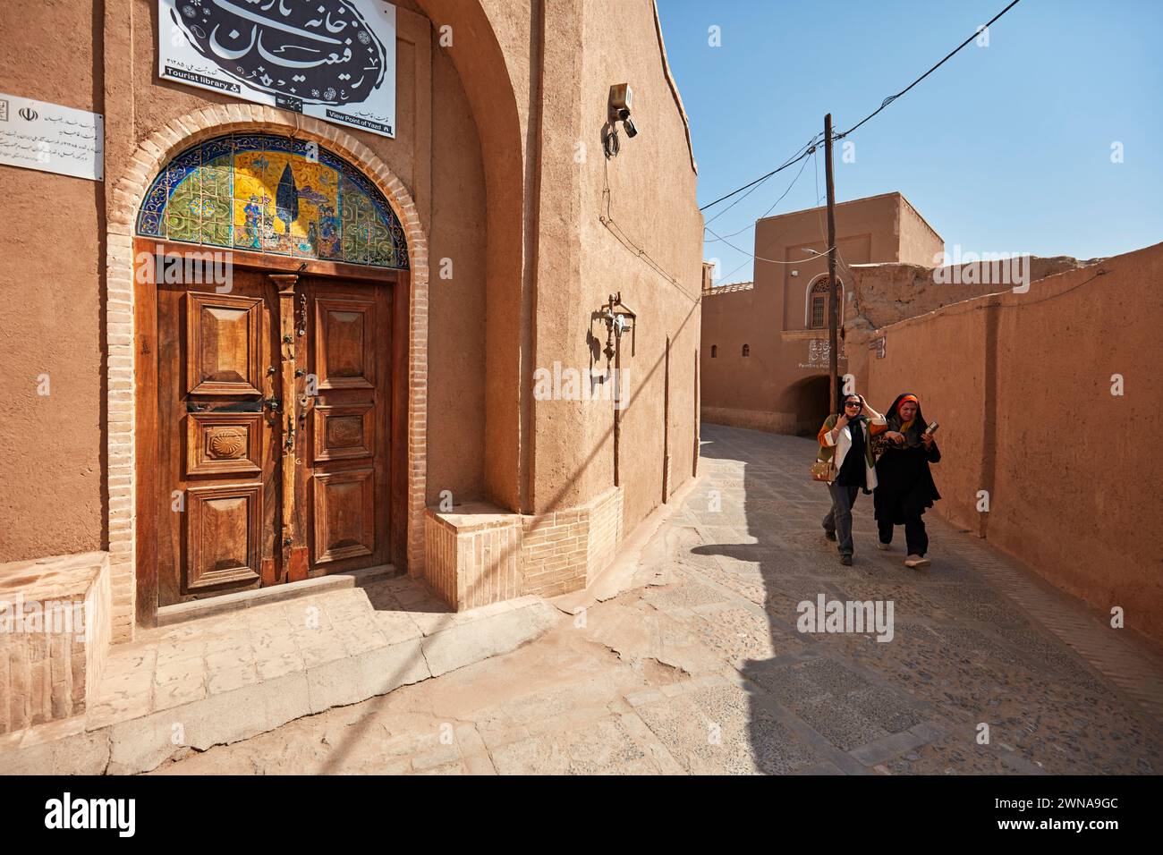 Two Iranian women walk in a narrow street near the Rafiean's Old House ...