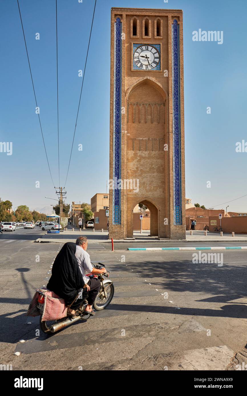 Man and woman on motorbike pass by the Clock Tower in the Al-Saat ...