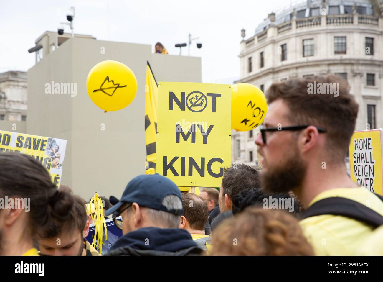 Anti-monarchy placards are held as people gather to view the coronation ...