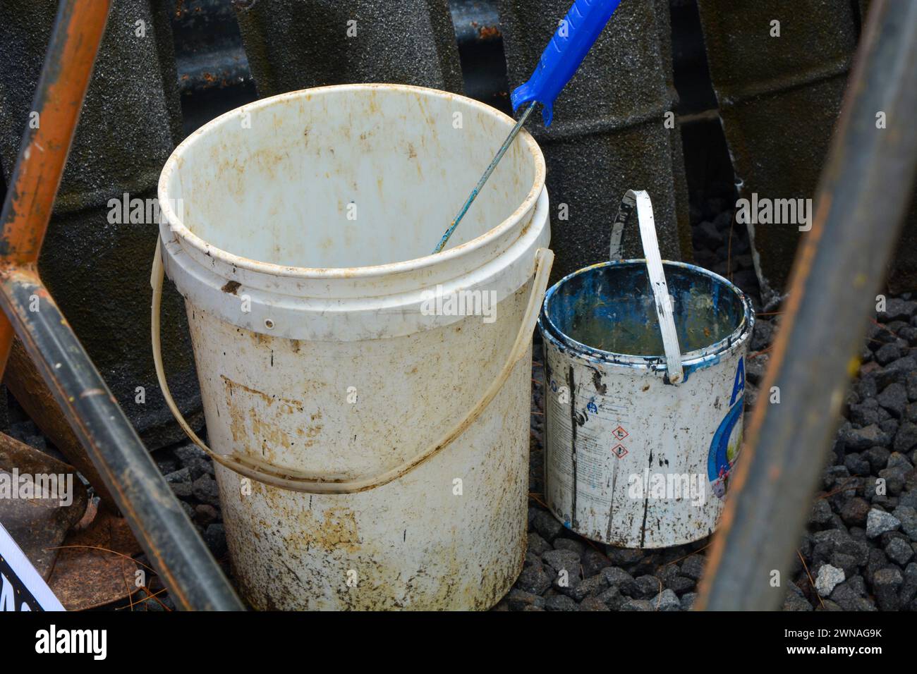 One large bucket and one small bucket of used paint placed on the ...