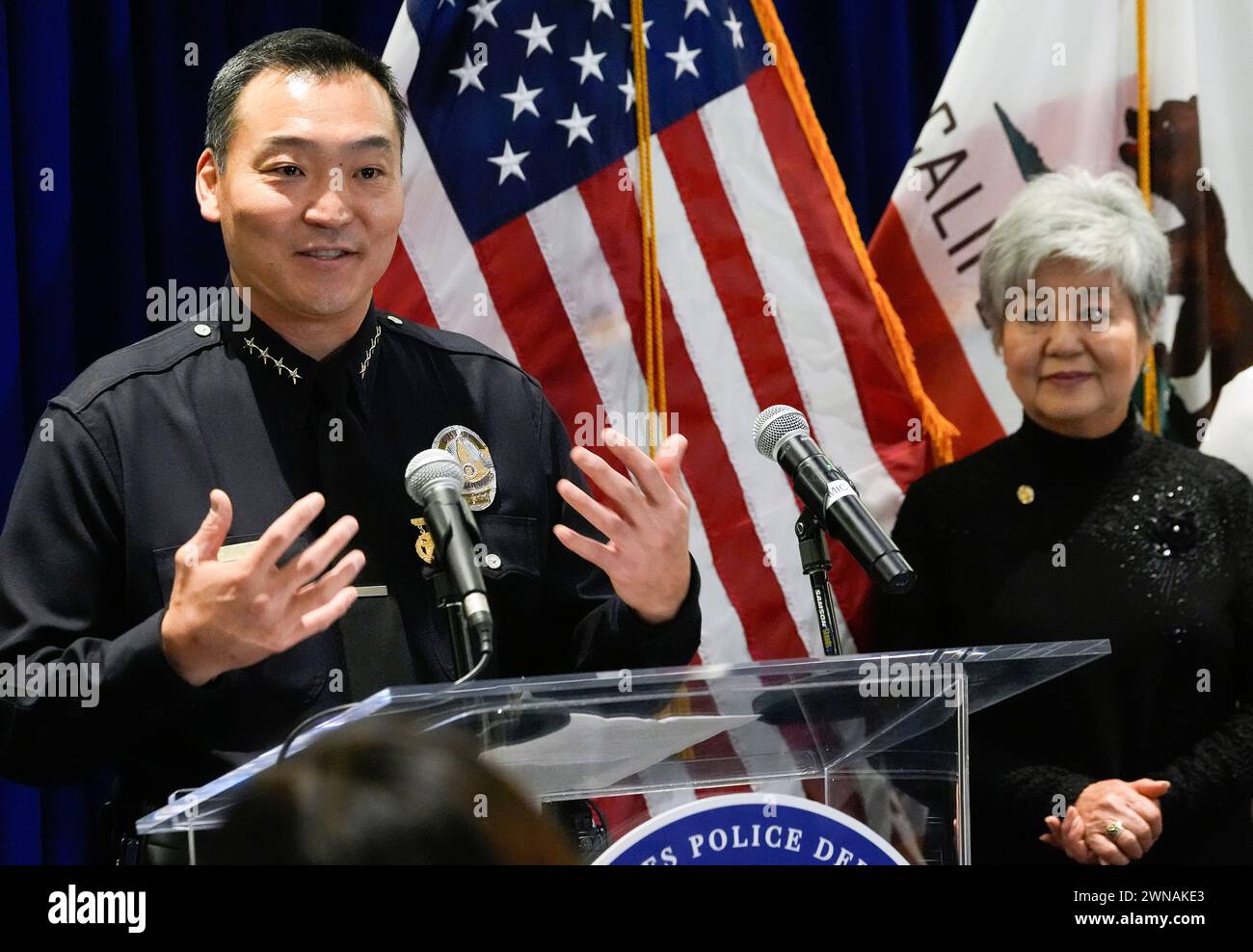 Chief Dominic H. Choi, speaks as his mother Jin, looks on after being ...