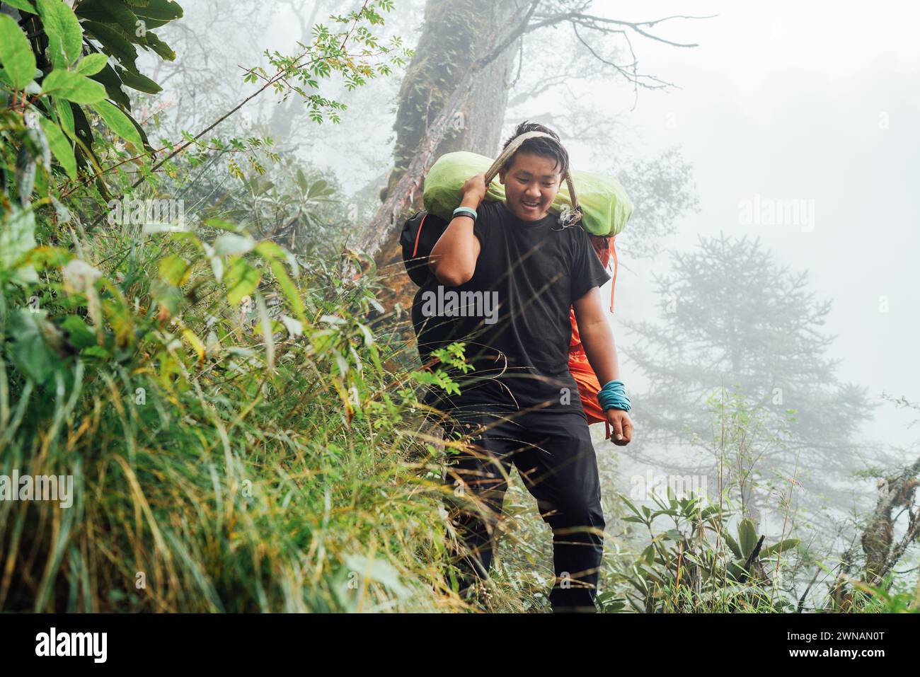 Portrait of strong Sherpa man working as porter carrying huge cargo ...