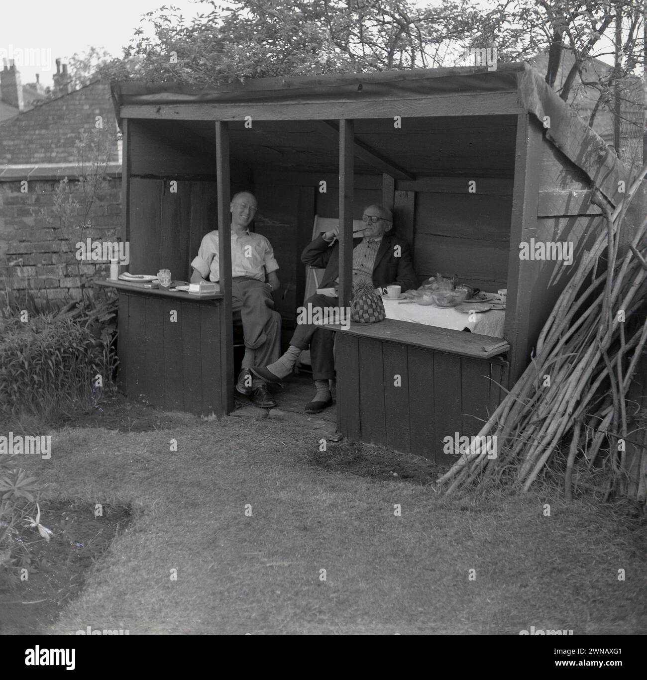 1950s, historical, two gentleman relaxing having tea in an open wooden ...