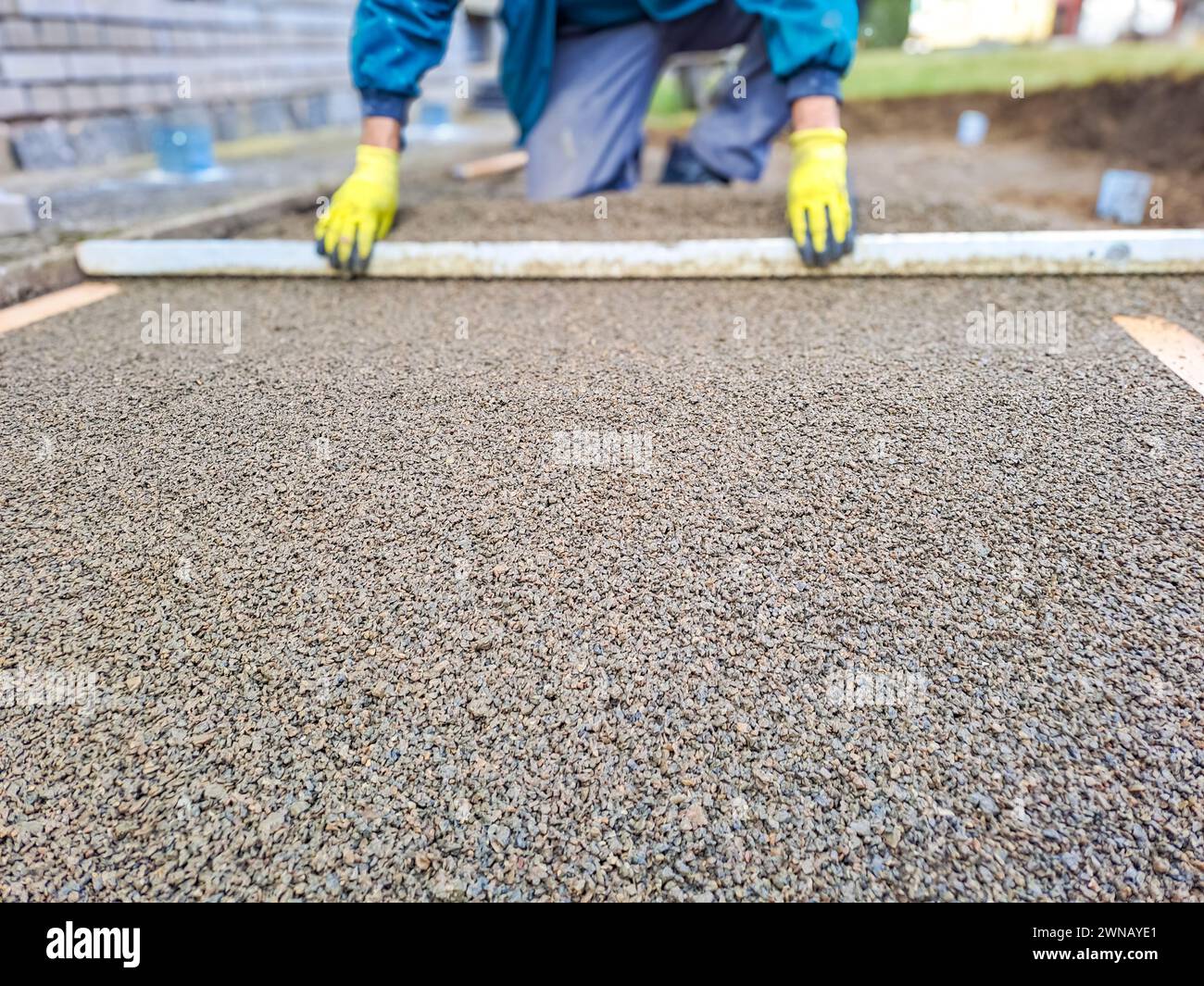 Laying gray concrete paving slabs in house courtyard driveway ...