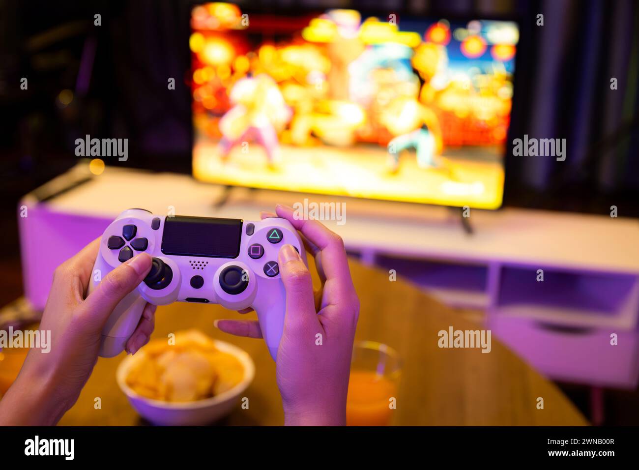 Close up one hand's woman player of video game on TV using joystick ...