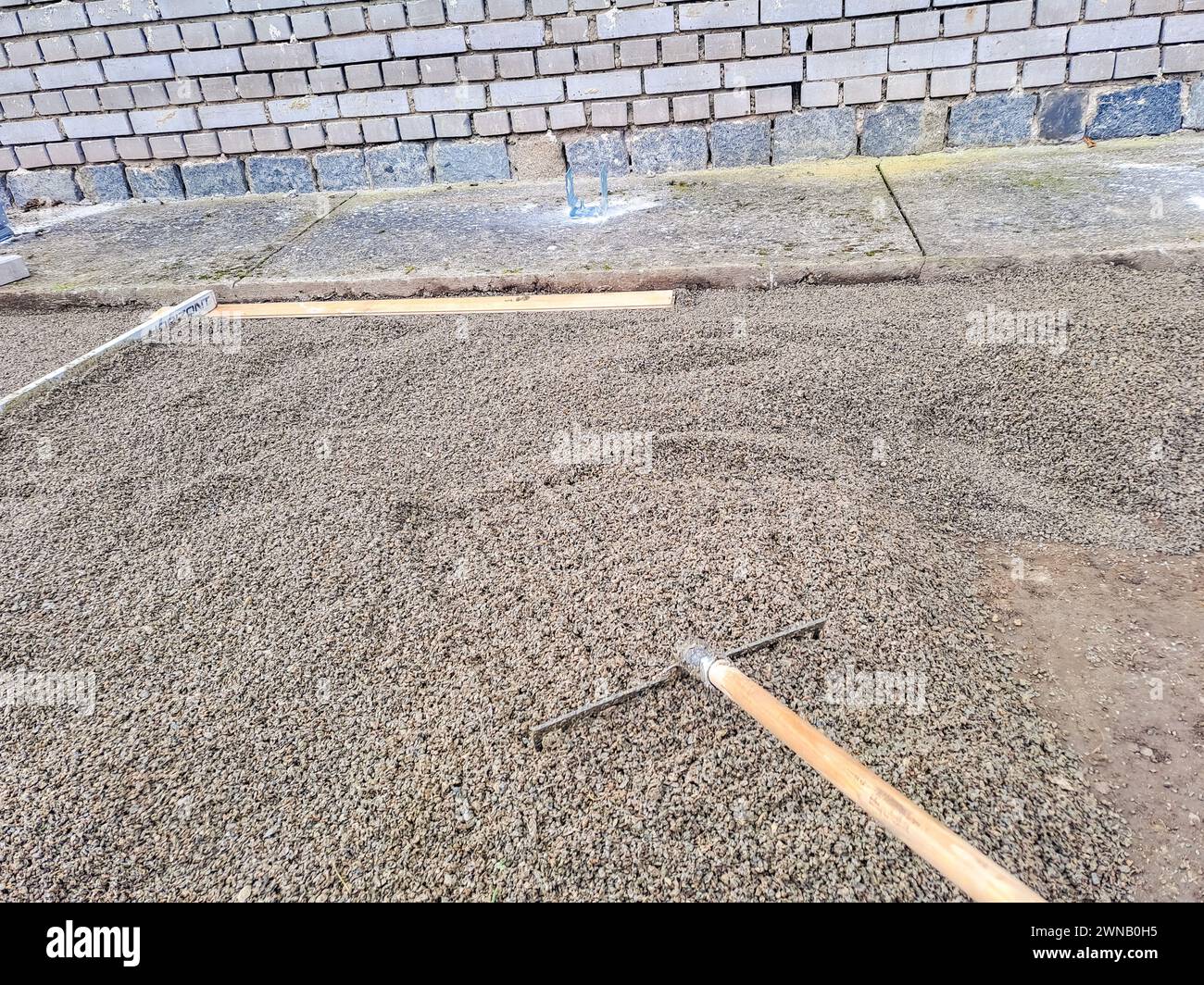 Laying gray concrete paving slabs in house courtyard driveway ...