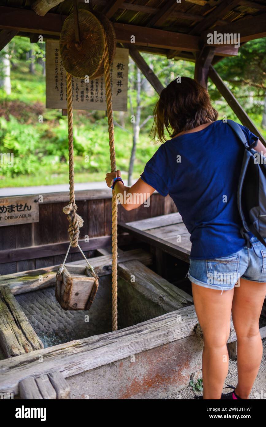 Young woman using well in Hida Folk Village, Hida no Sato open-air ...