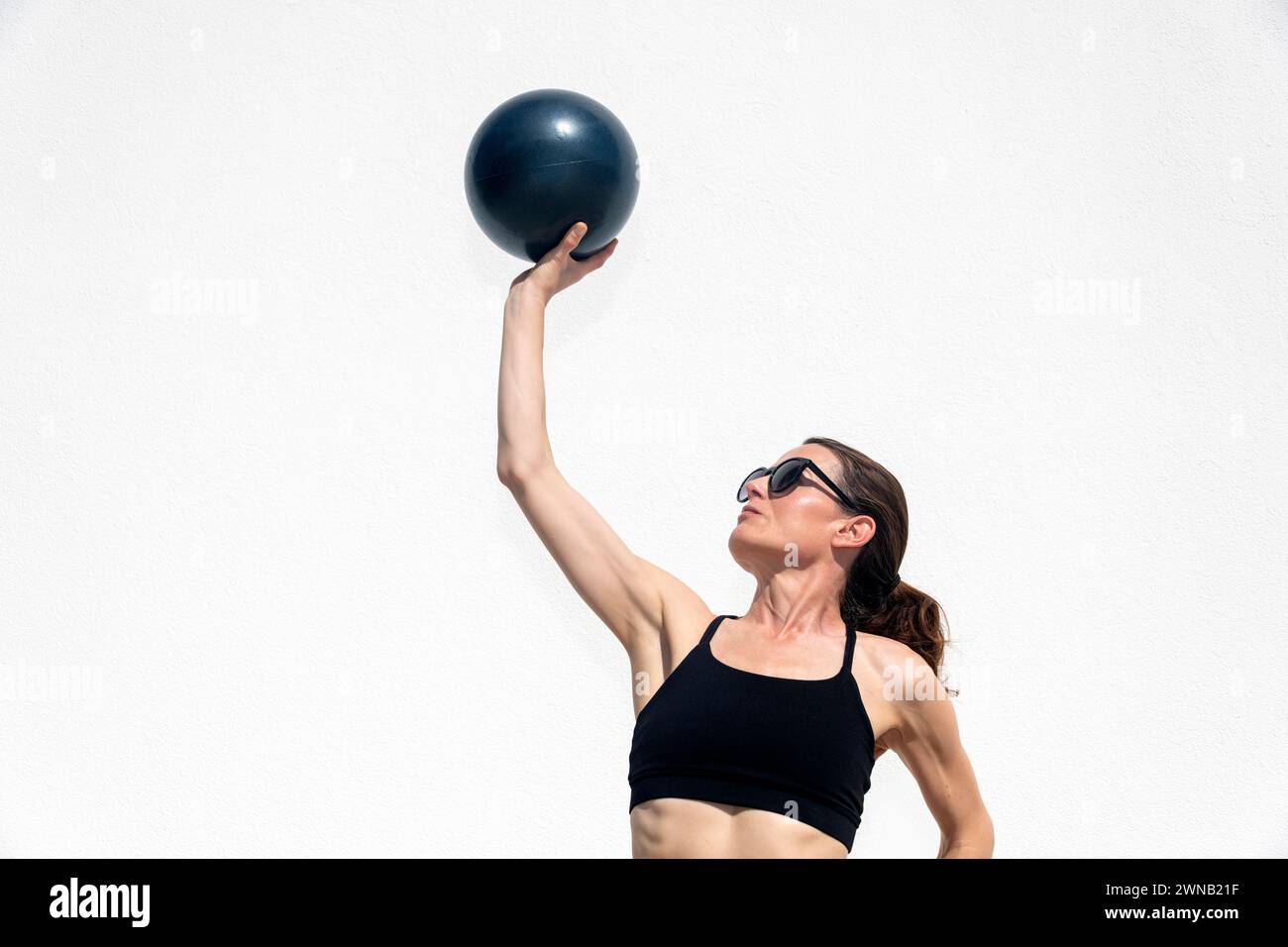 Sporty woman catching or throwing a ball, fitness exercise concept ...