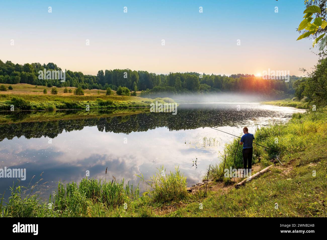 In the early summer morning, a fisherman is fishing in the upper ...