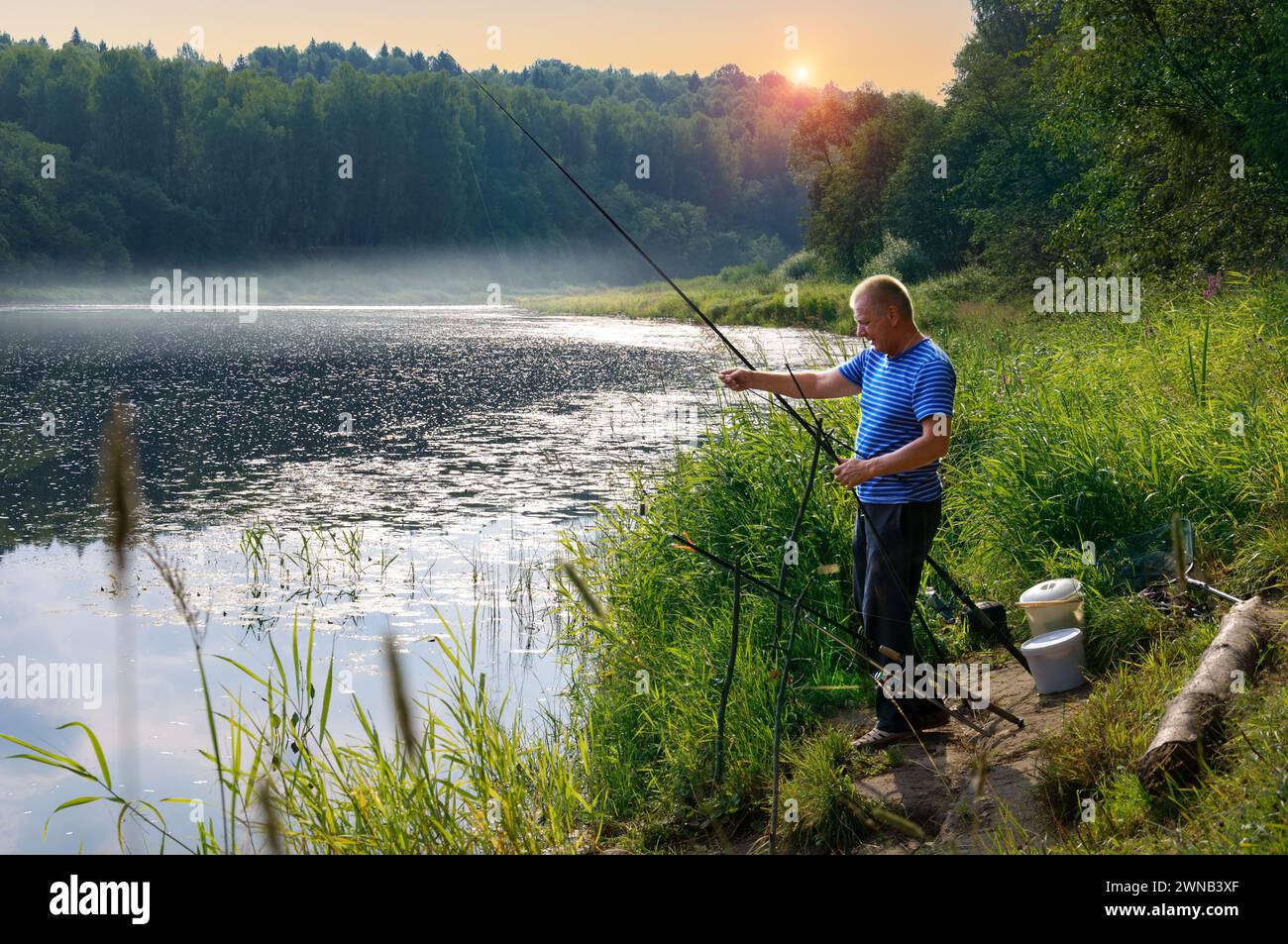 In the early summer morning, a fisherman is fishing in the upper ...