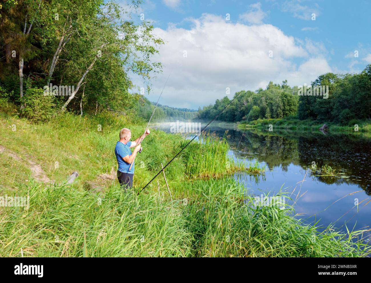In the early summer morning, a fisherman is fishing in the upper ... In the early summer morning, a fisherman is fishing in the upper ...