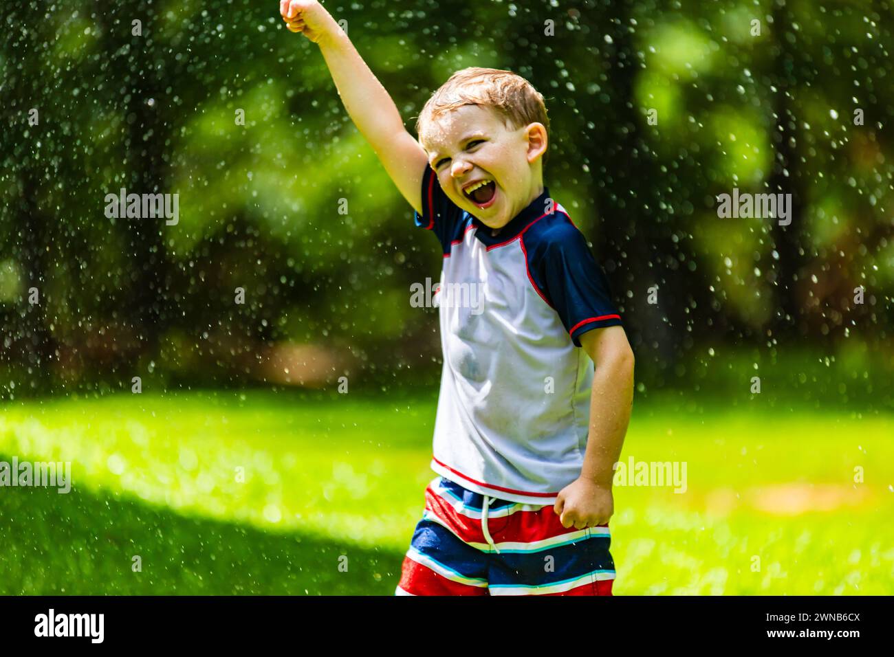 Young child having fun in outdoor sprinkler Stock Photo - Alamy