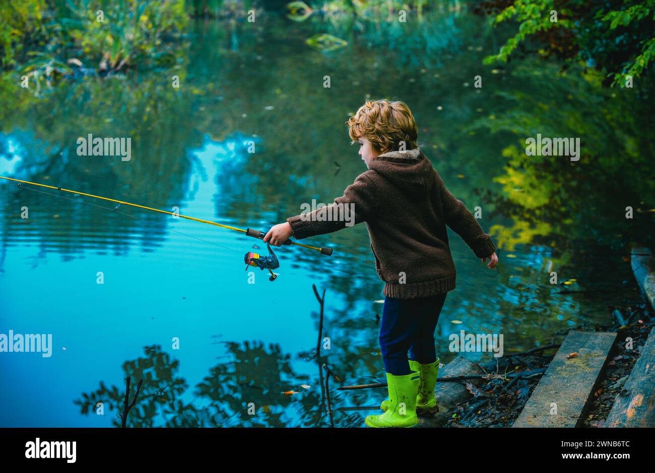 Cute child little boy pulling rod while fishing on lake Stock Photo - Alamy