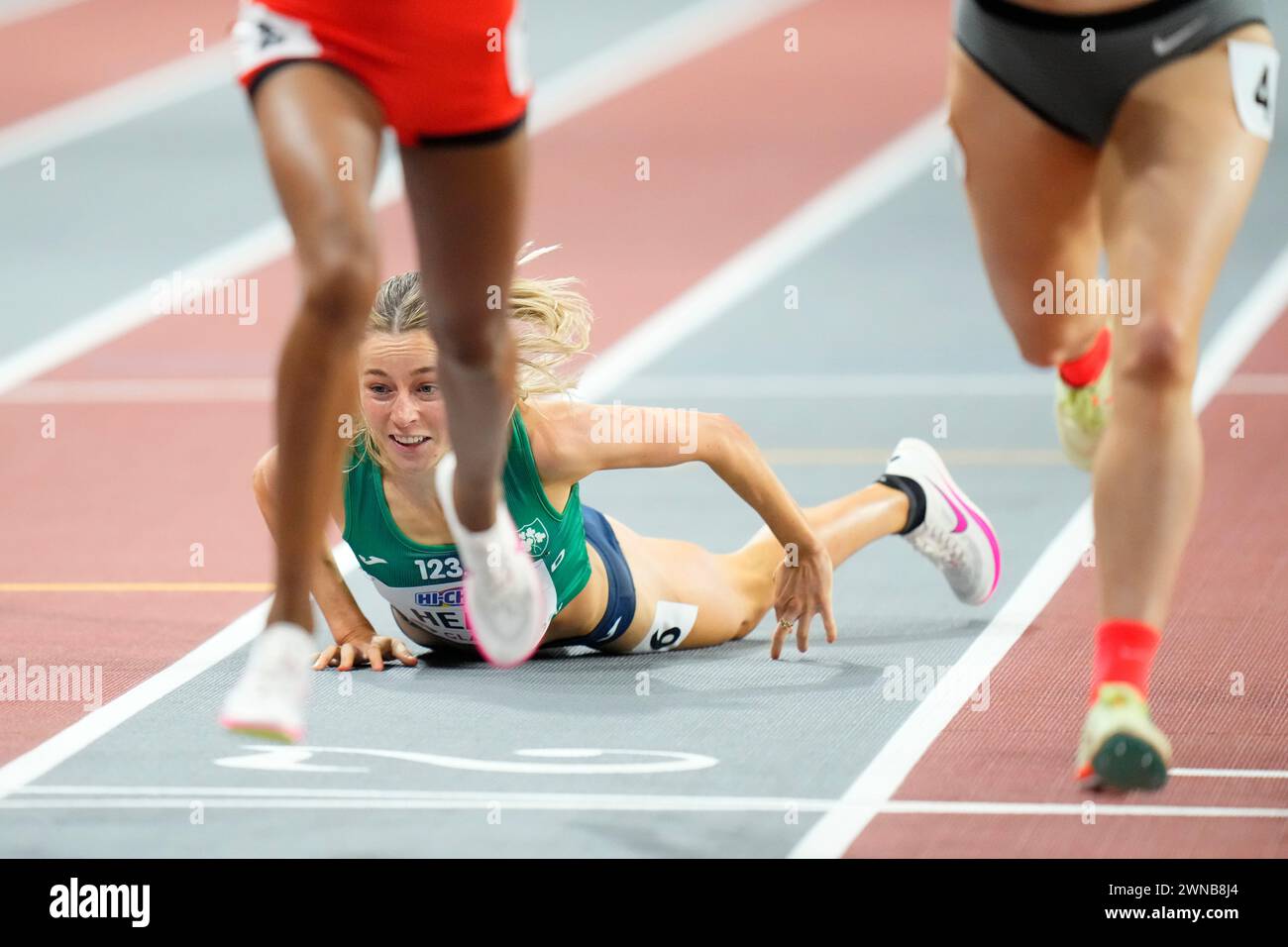 Sarah Healy, of Ireland, falls to the ground approacing the finish line ...