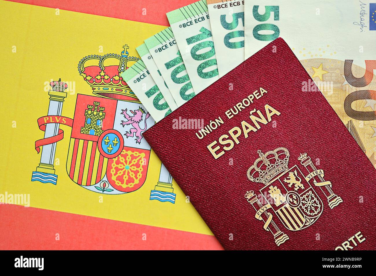 Red Spanish passport of European Union and money on flag background ...