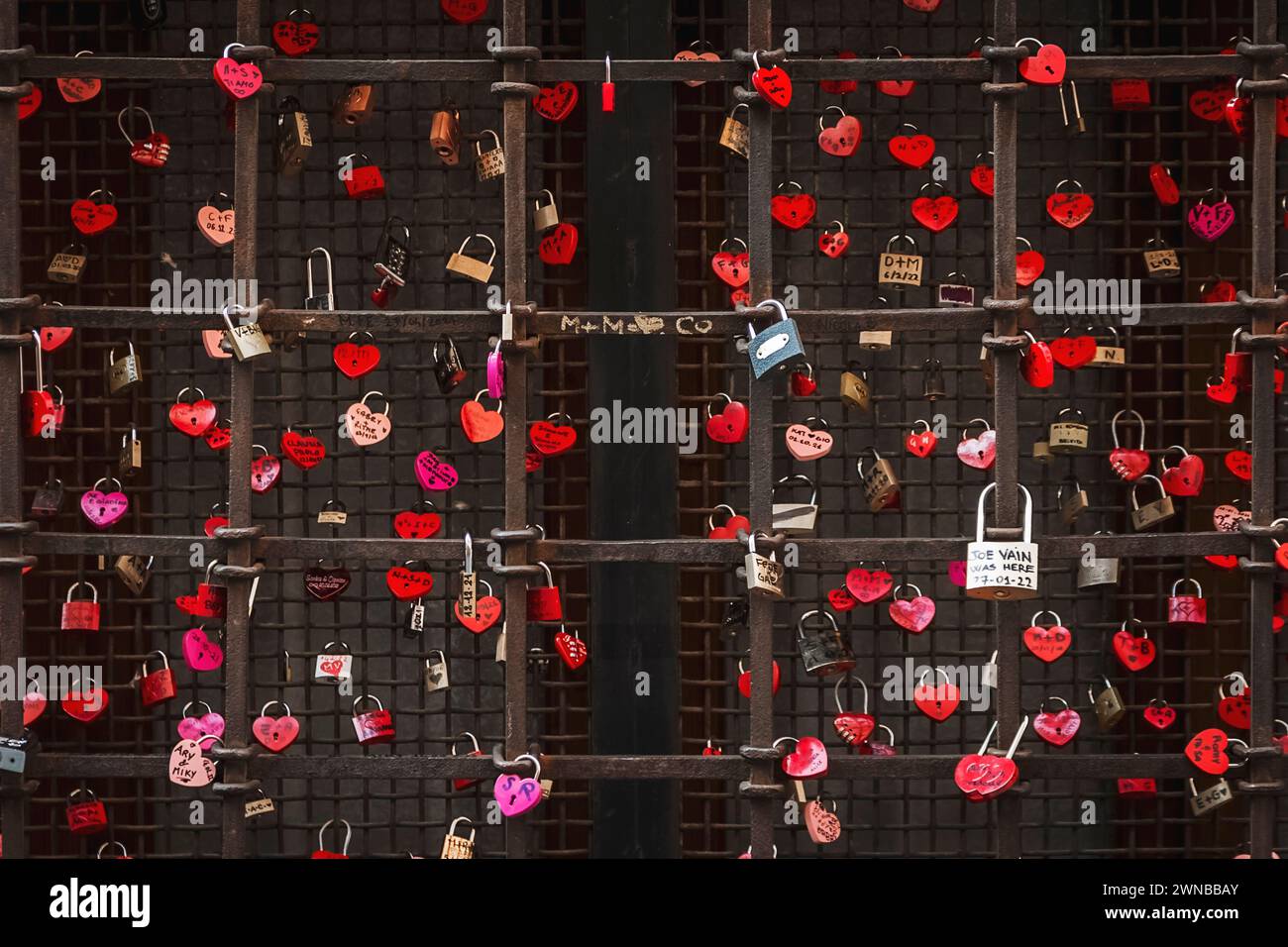 padlocks in the shape of a red heart attached to the railings to ...