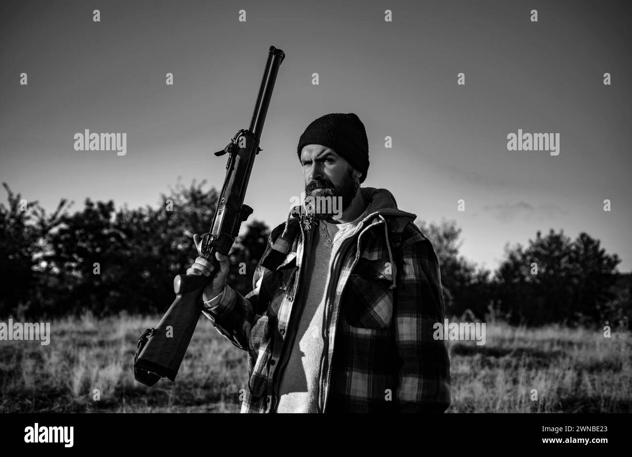 Hunter with shotgun gun on hunt. Bearded hunter man holding gun and ...