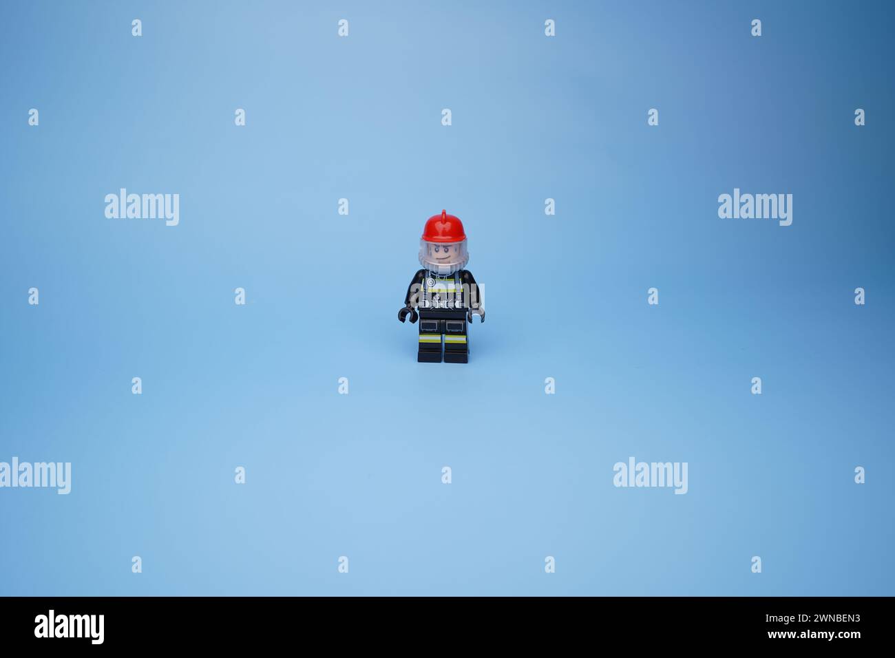 A Lego firefighter isolated against an empty blue background Stock ...