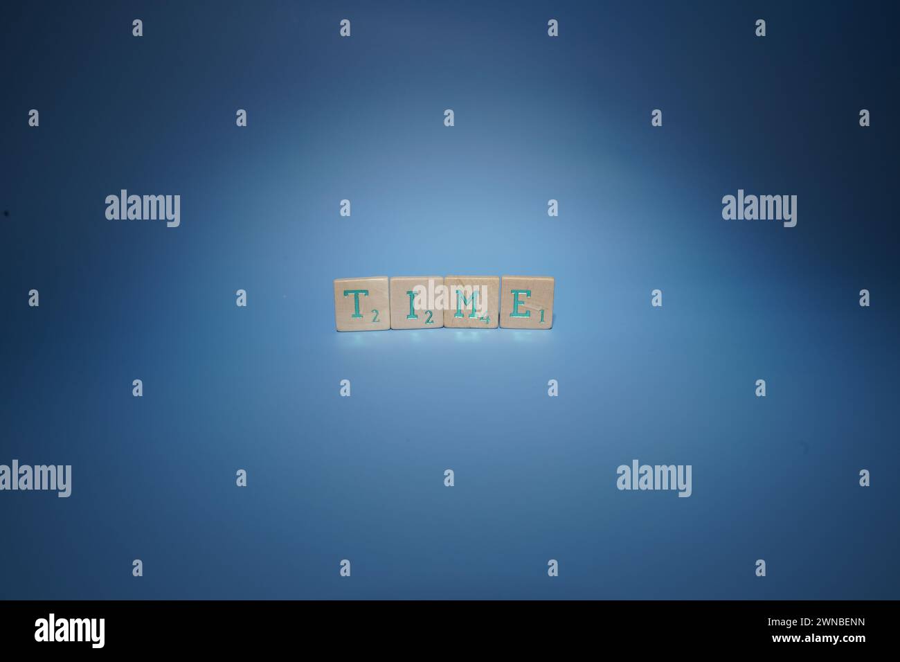 The Wooden letters spell time against a blue backdrop Stock Photo - Alamy