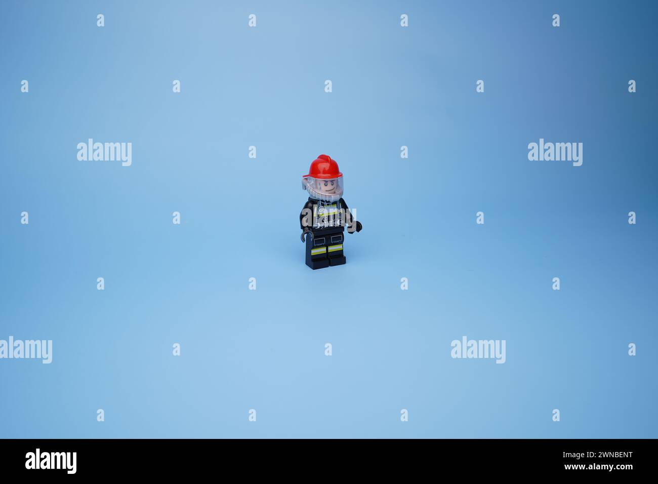 A Lego firefighter isolated against an empty blue background Stock ...