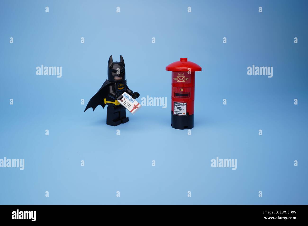 A Lego Batman isolated against an empty blue background Stock Photo - Alamy