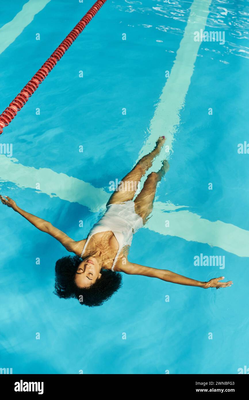top view of young and curly african american woman swimming on back in ...