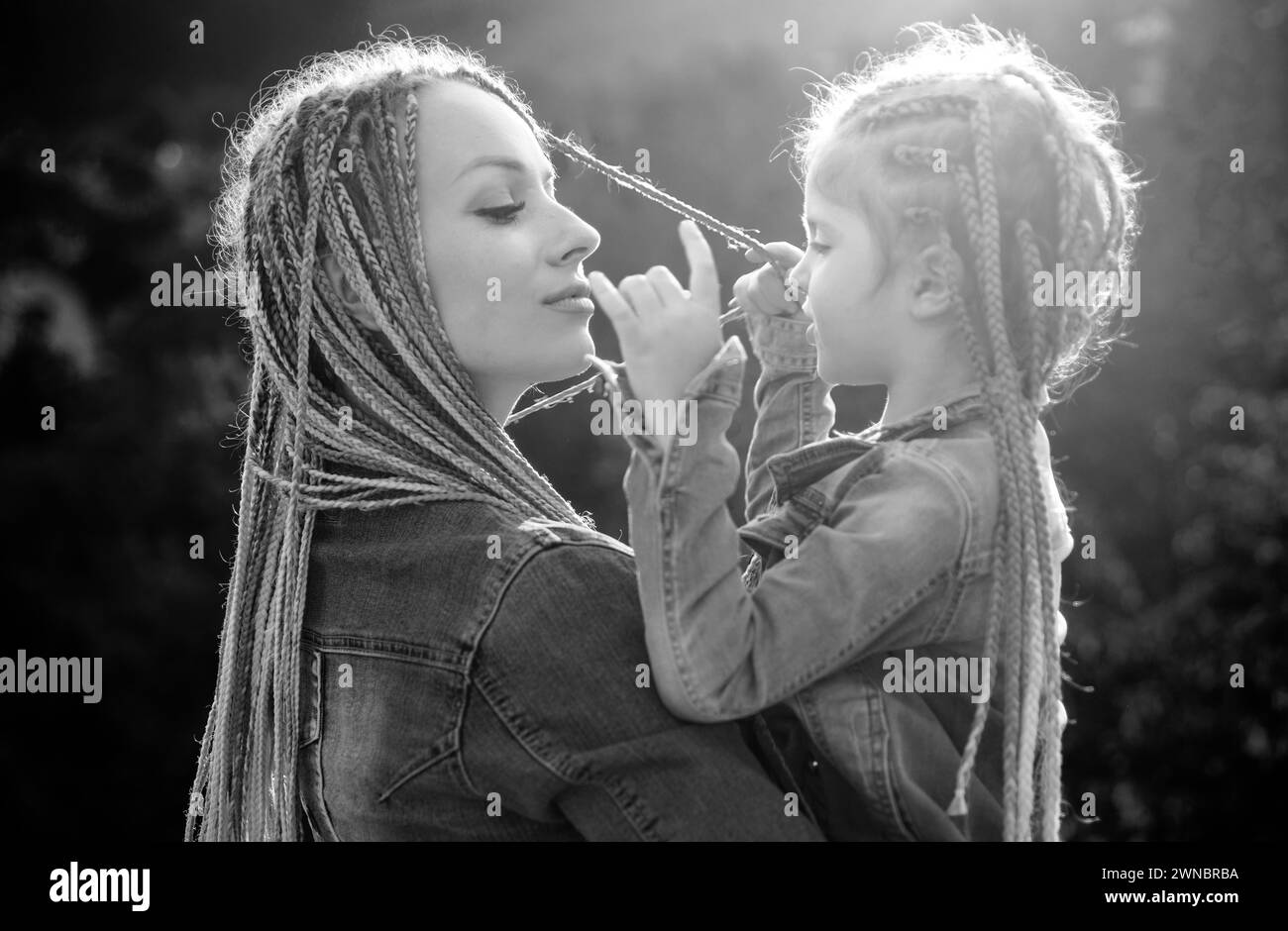 Mother and daughter with braiding hair. Nice child girl with plaits. Hair in trendy weave plait ...