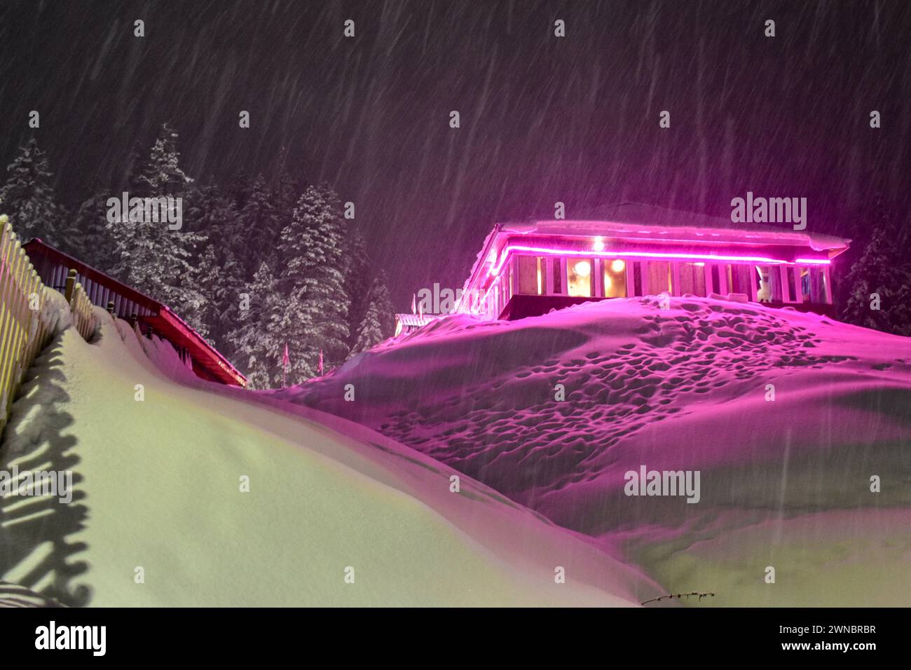 A late night view of the illuminated hut seen during a heavy snowfall ...
