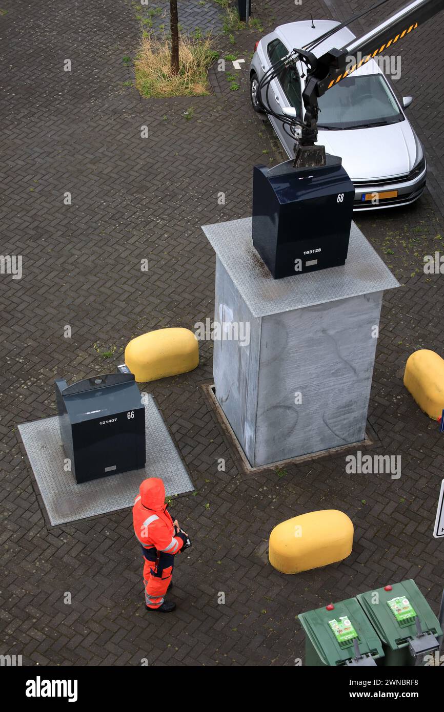 Underground residual waste containers being emptied by the municipal ...