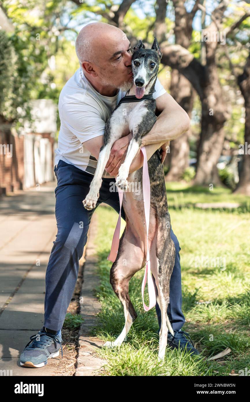 Vertical portrait of a middle-aged bald man kissing his rescued ...