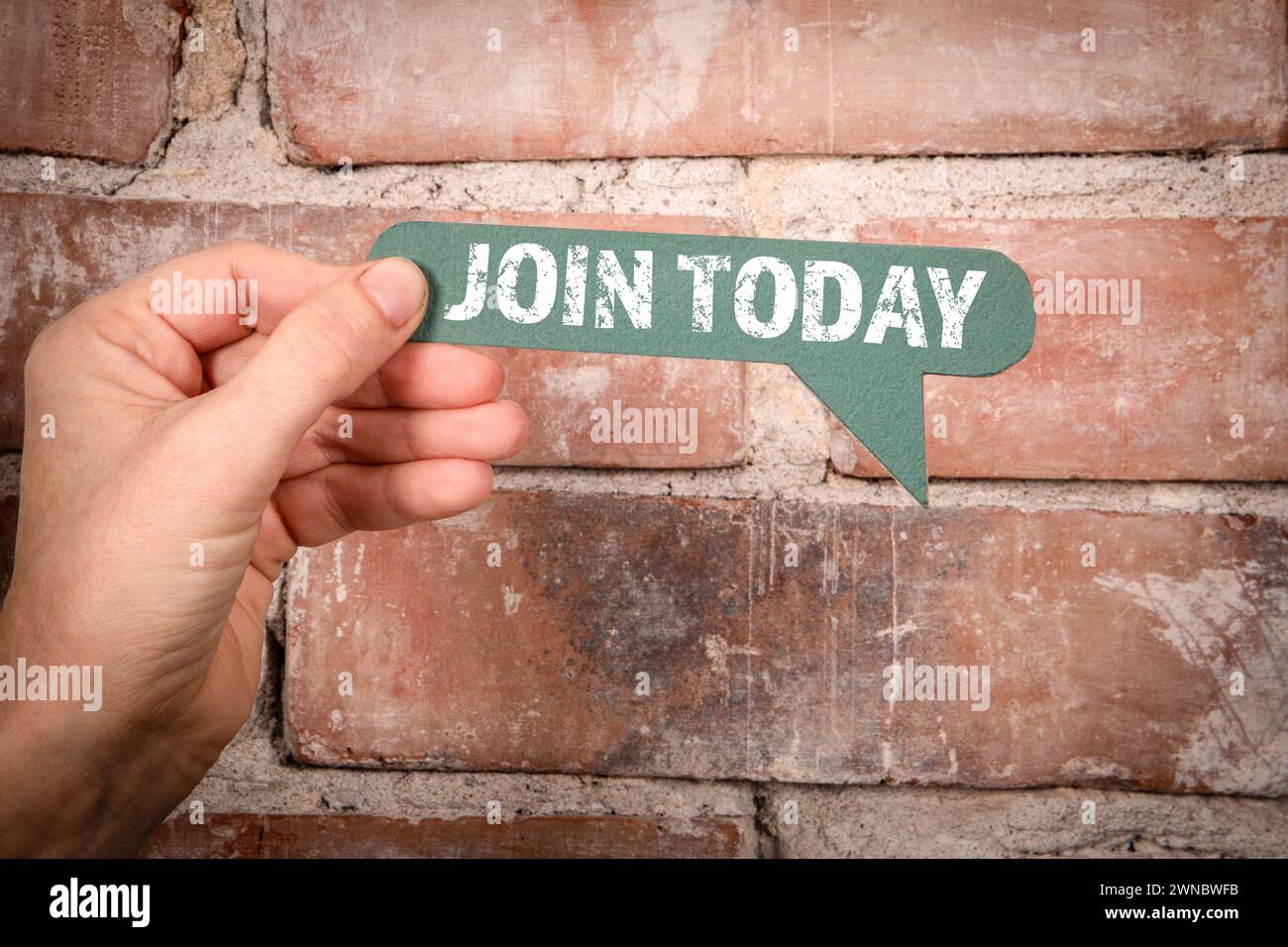 Join Today. Green speech bubble with text on a red brick background ...
