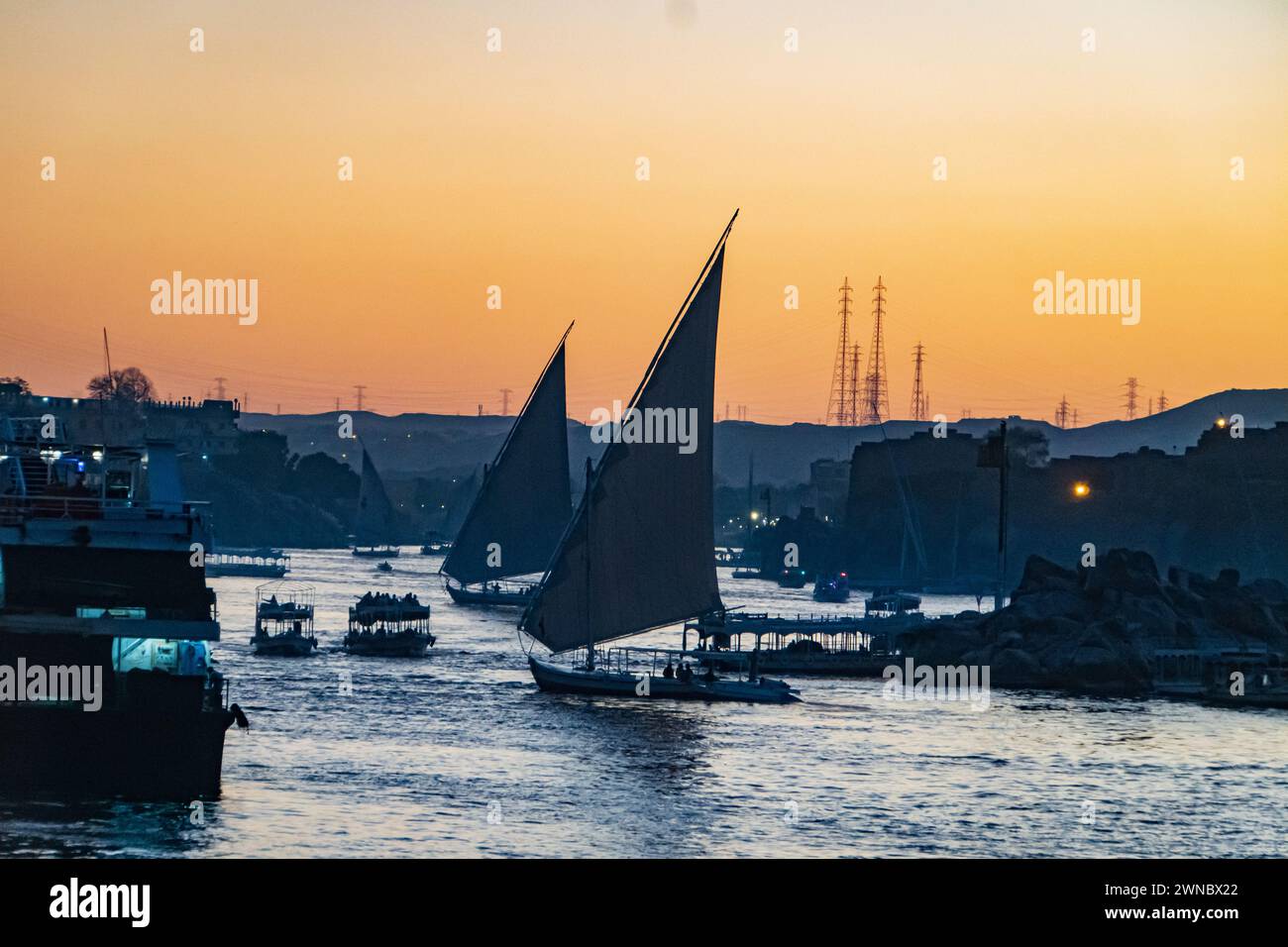 Boats and felucca sail boats on the Nile river at sunset in Aswan ...