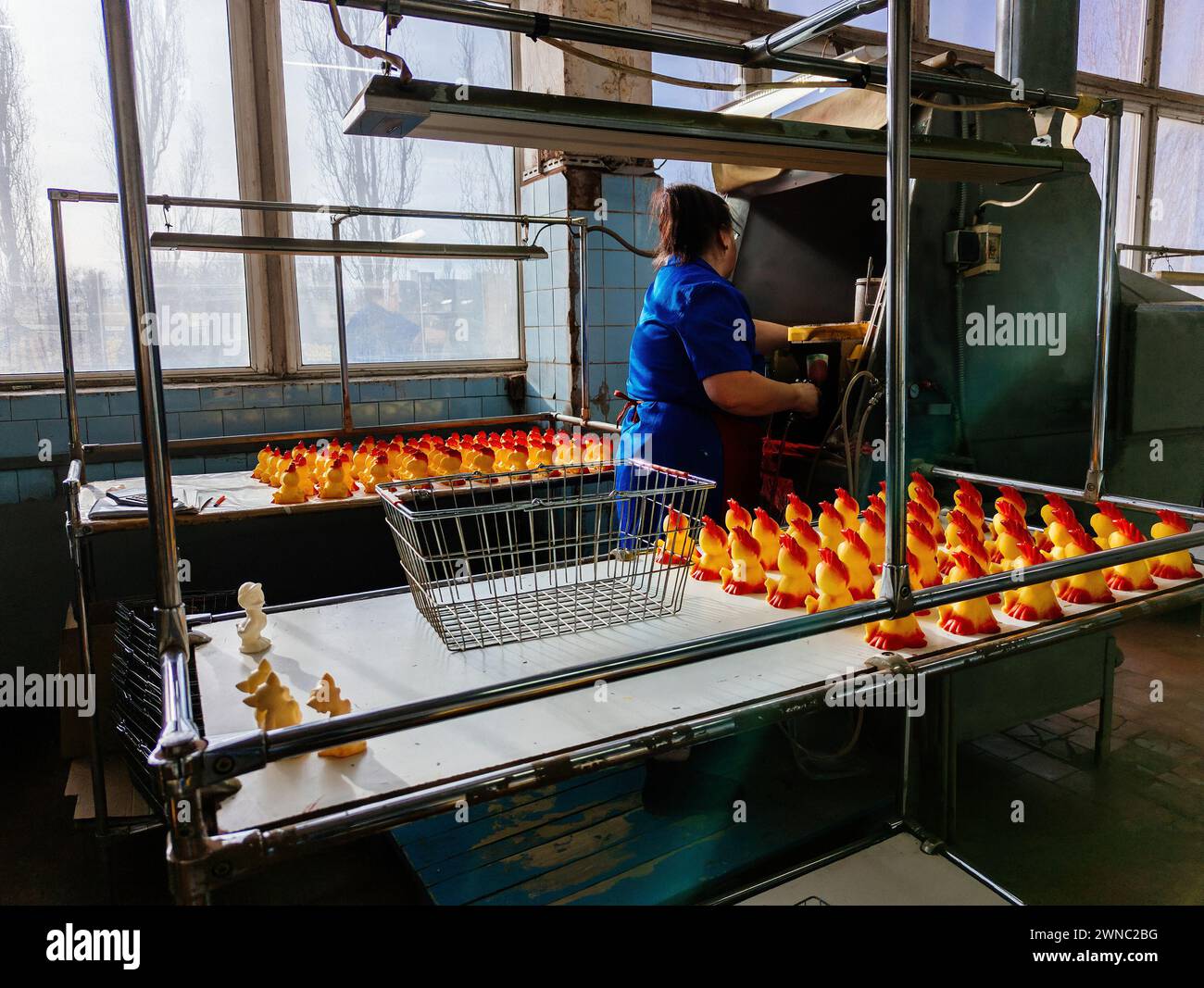 Worker is painting plastisol toys by paint sprayer in toy factory Stock ...