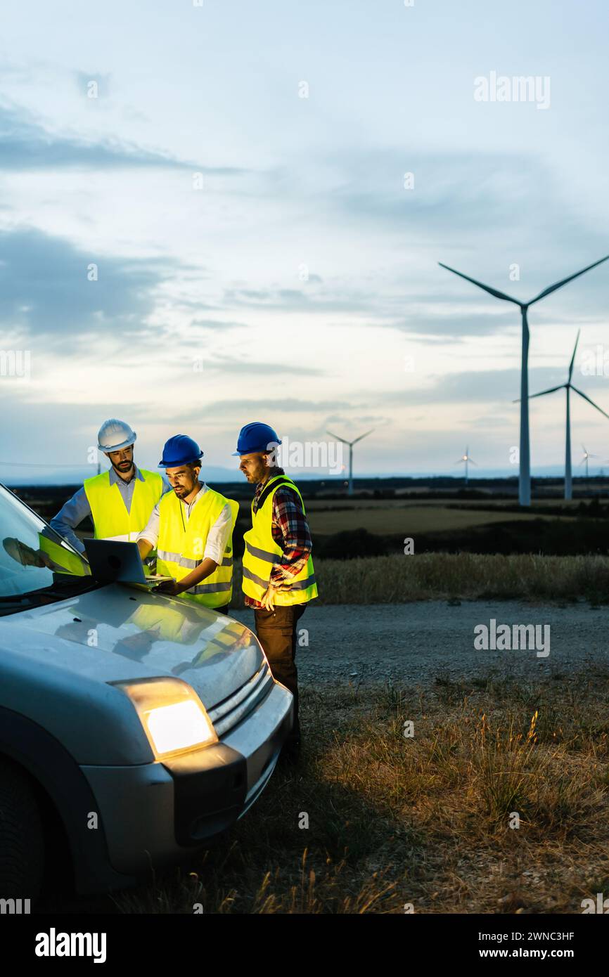 Engineers teamwork discussing renewable energy project at wind turbine ...
