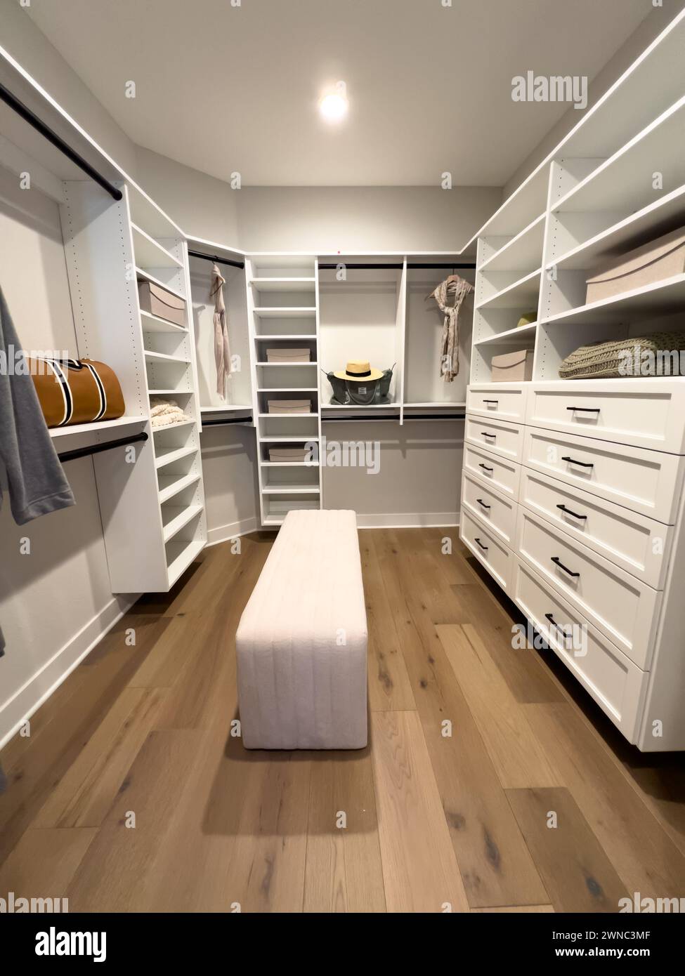 Spacious Walk-In Closet with Custom Shelving and Seating Stock Photo ...
