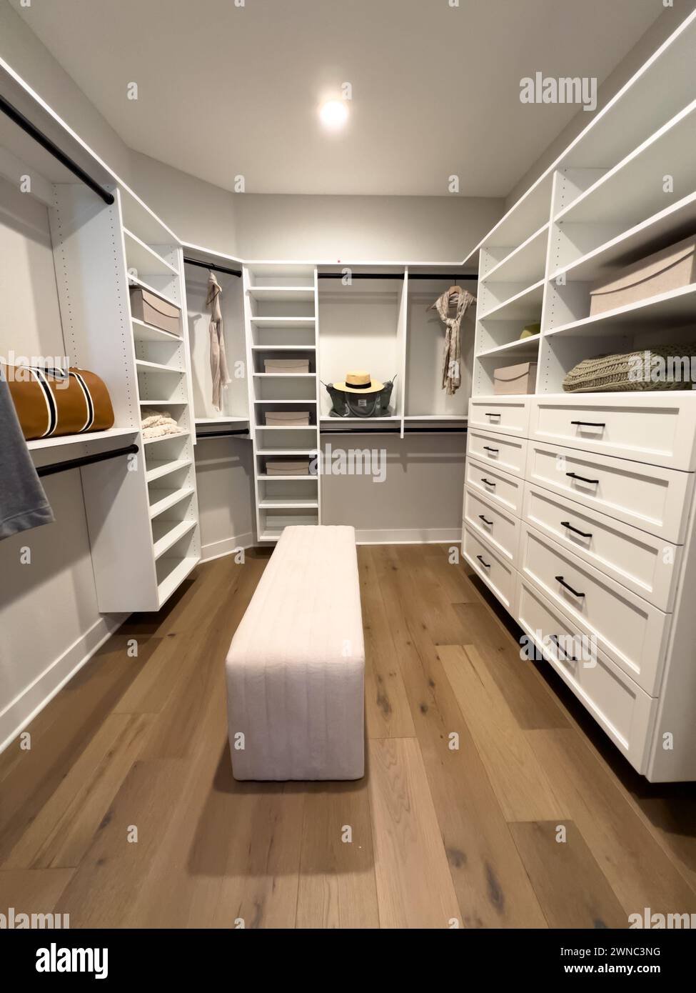 Spacious Walk-In Closet with Custom Shelving and Seating Stock Photo ...