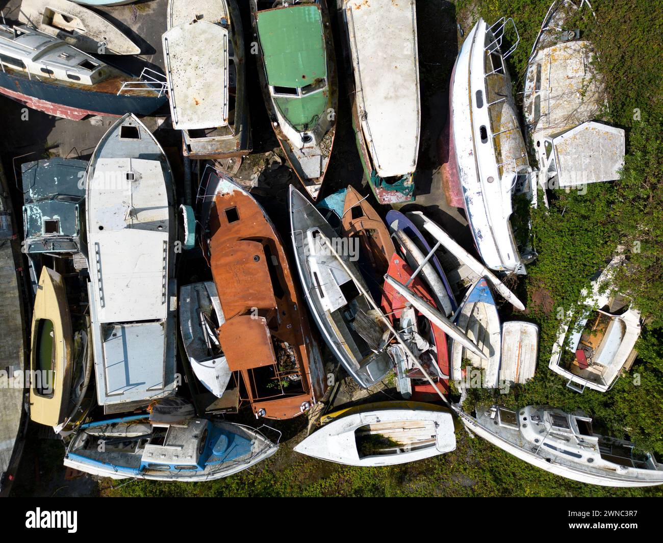 Close-up of corroded and disposed boats dumped at a scrapyard for later ...