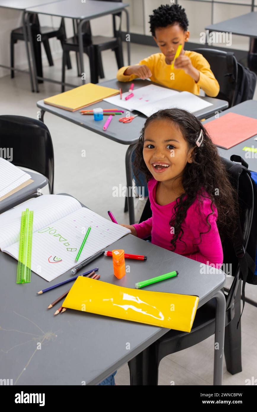 African American boy and biracial girl are focused on their schoolwork ...