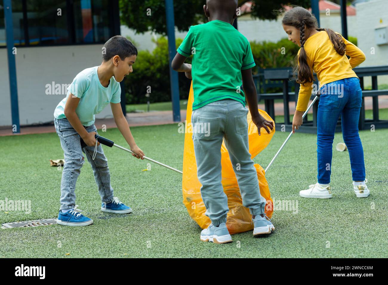 Three children are collecting trash in school Stock Photo - Alamy