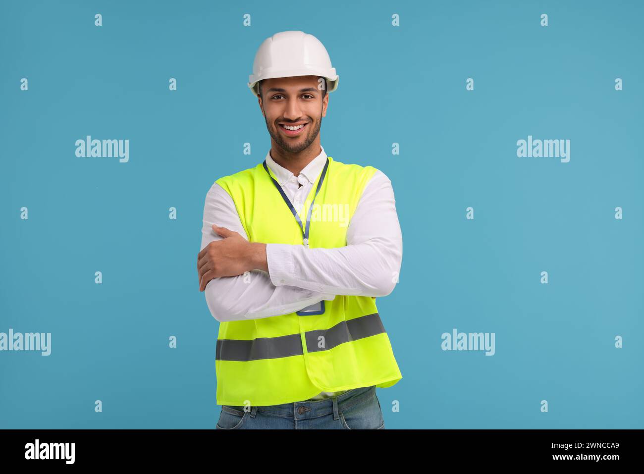 Engineer in hard hat on light blue background Stock Photo - Alamy