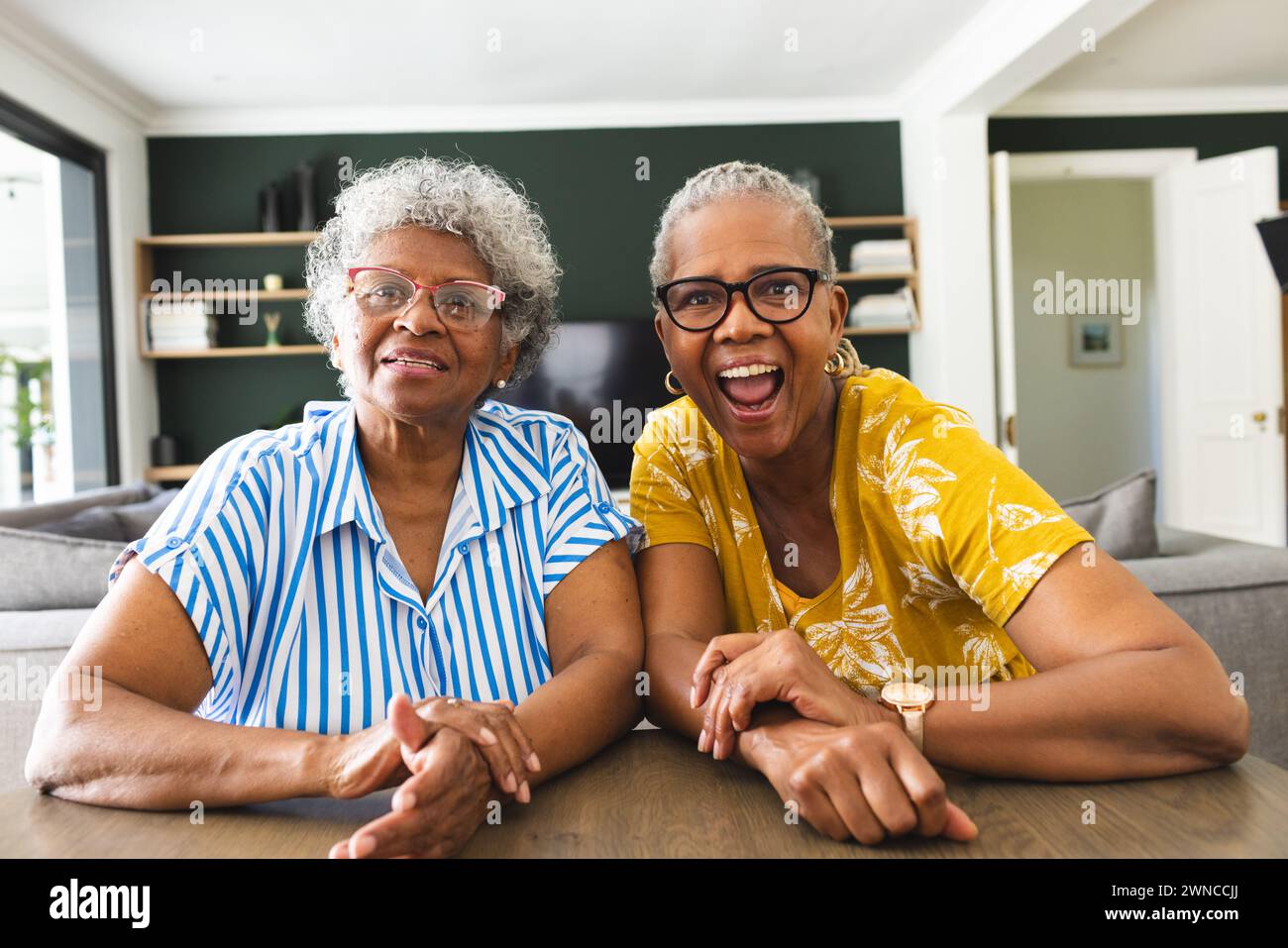 Two senior women enjoy a warm video call at home, radiating joy Stock ...