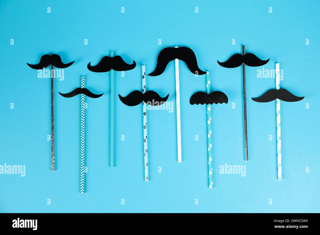 Fake paper mustaches with party props on light blue background, flat ...
