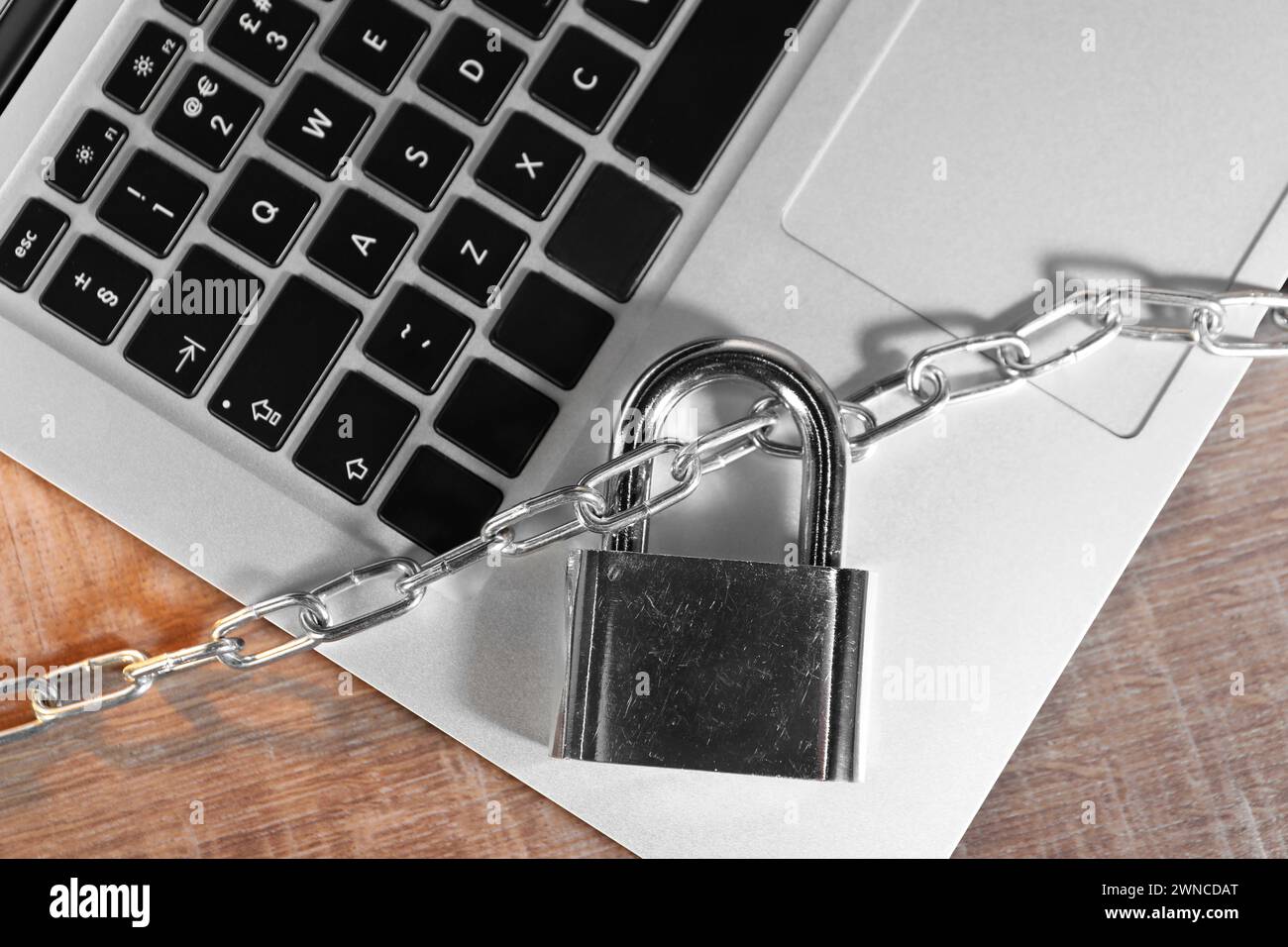 Cyber security. Laptop with padlock and chain on wooden table, top view ...