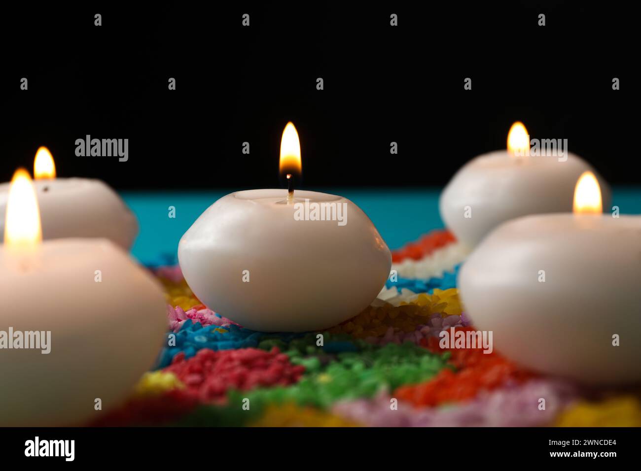 Diwali celebration. Burning candles and colorful rangoli against black ...
